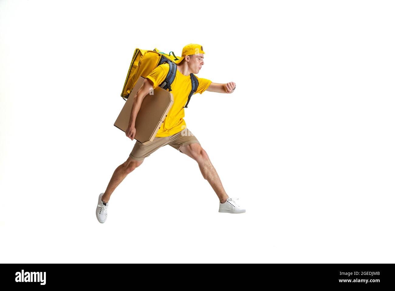 Young delivery man in yellow uniform hurry up to deliver order isolated ...