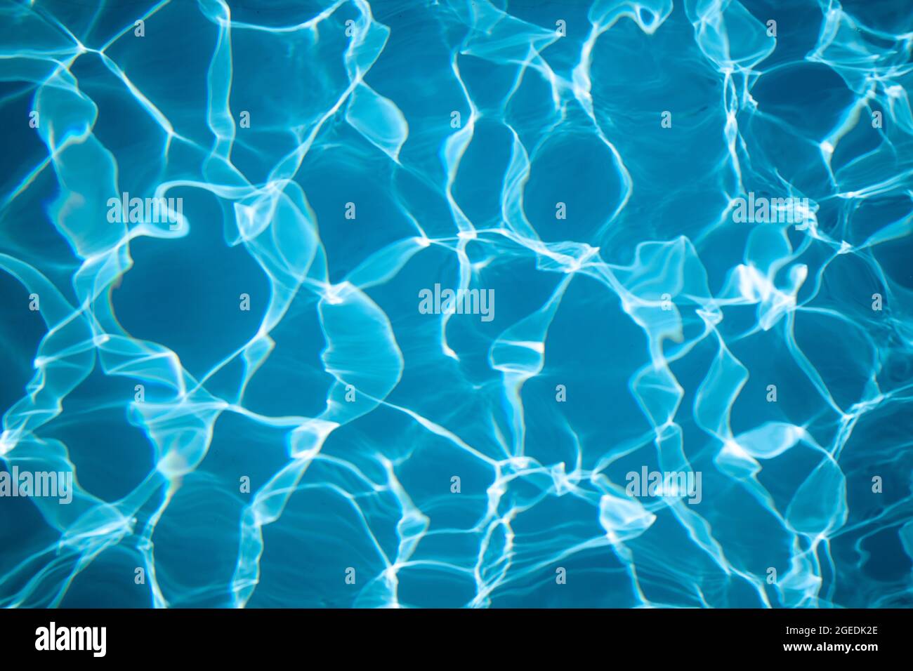 Reflection of sunlight in the water of a swimming pool with blue cast ...