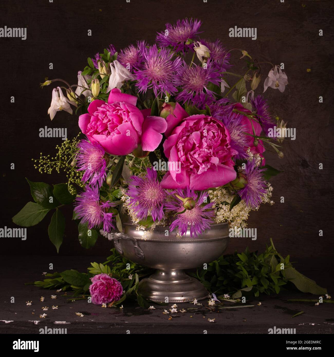 Bouquet of spring flowers in in a pewter vase on a dark Stock Photo - Alamy