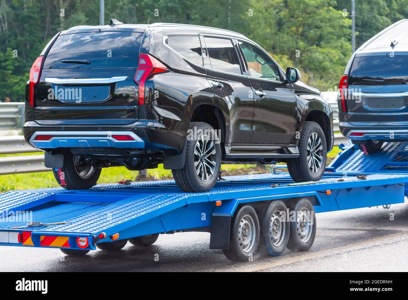Cars carrier trailer with new car on highway Stock Photo - Alamy