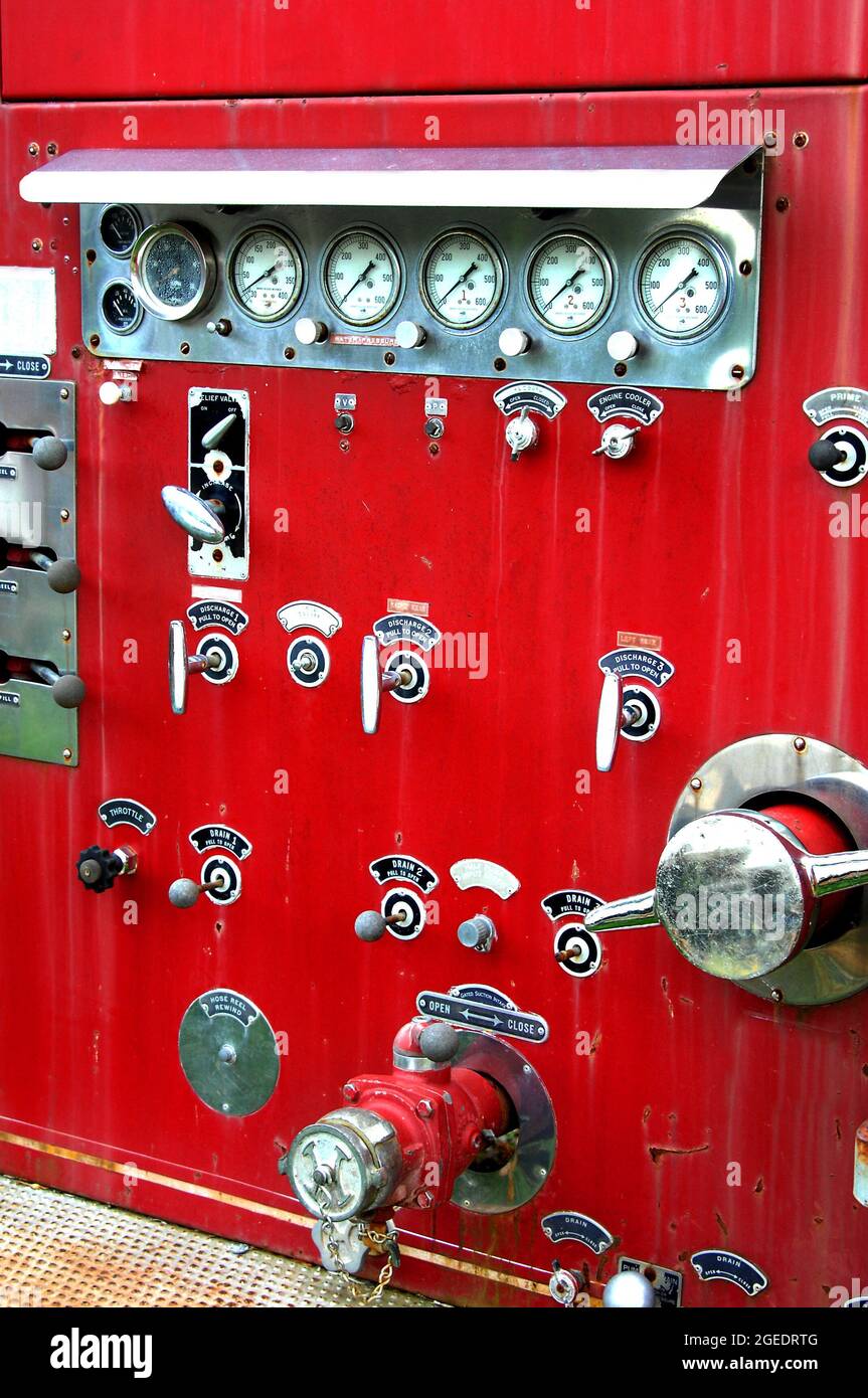 Controls on an antique fire engine are faded and worn. Red paint is ...