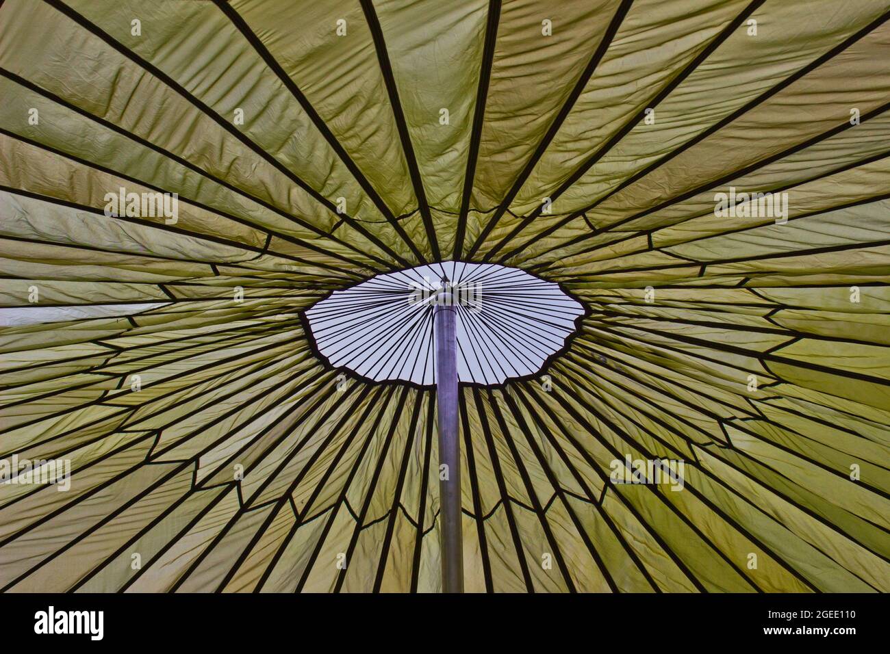 Low angle shot of a large yellow umbrella captured from the bottom ...