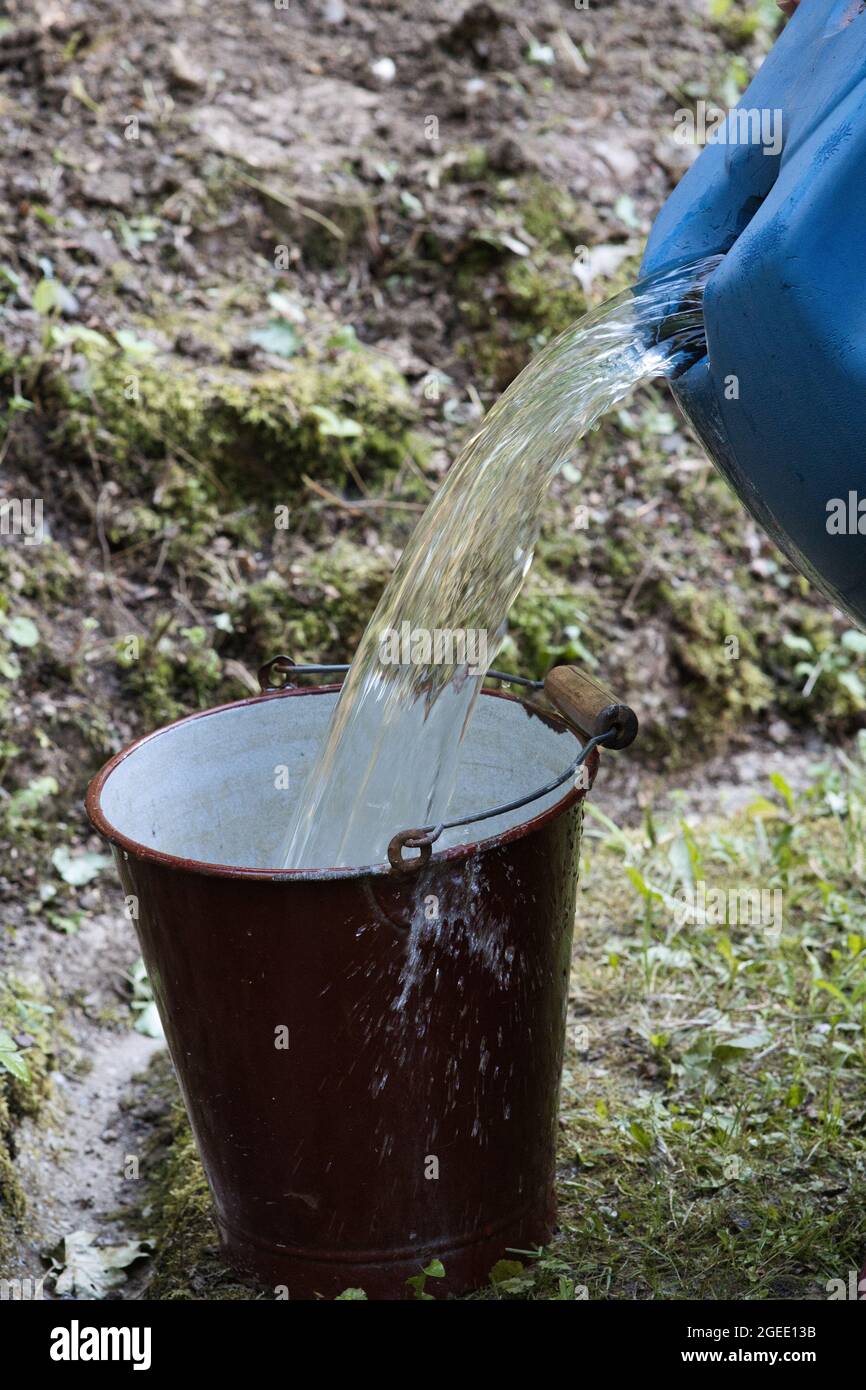 Process of pouring water in a bucket outdoors Stock Photo - Alamy