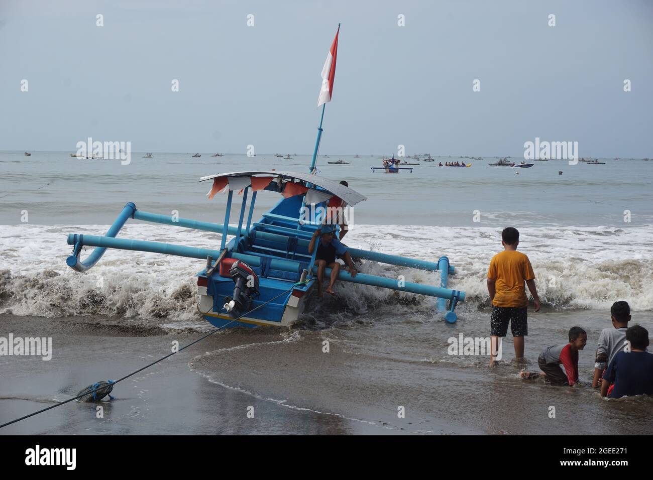 Children are playing on the traditional boat in Gemah Beach, Tulung ...