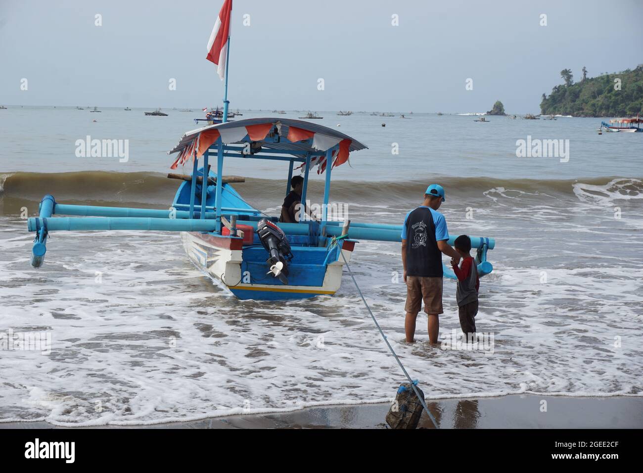 Children are playing on the traditional boat in Gemah Beach, Tulung ...