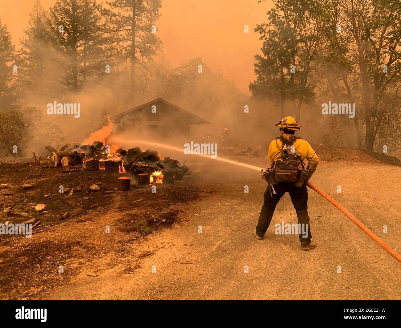 A firefighting from CalFire uses water to save a structure at the ...