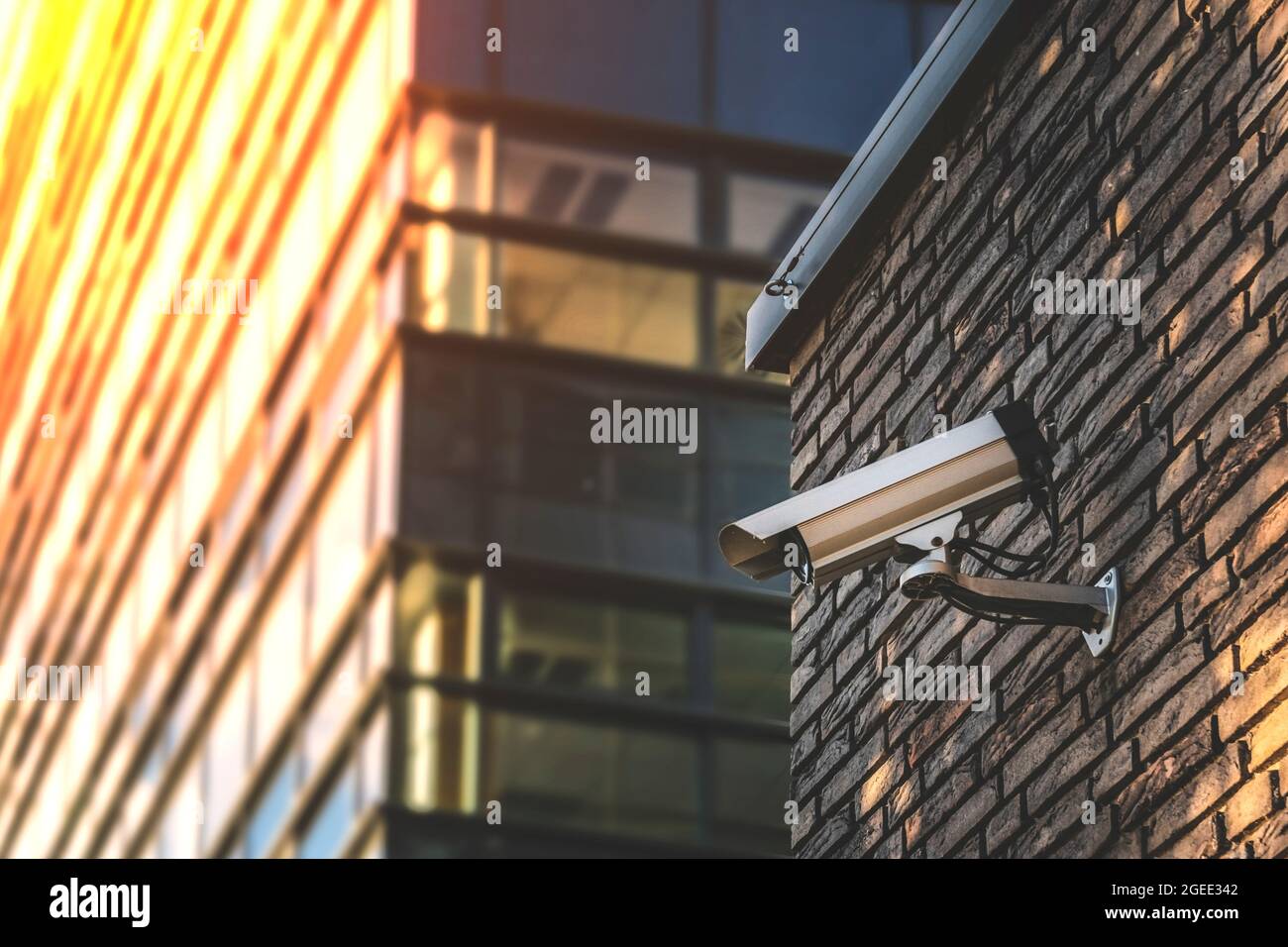 Close up of a camera attached to a brick wall outside. Security camera ...