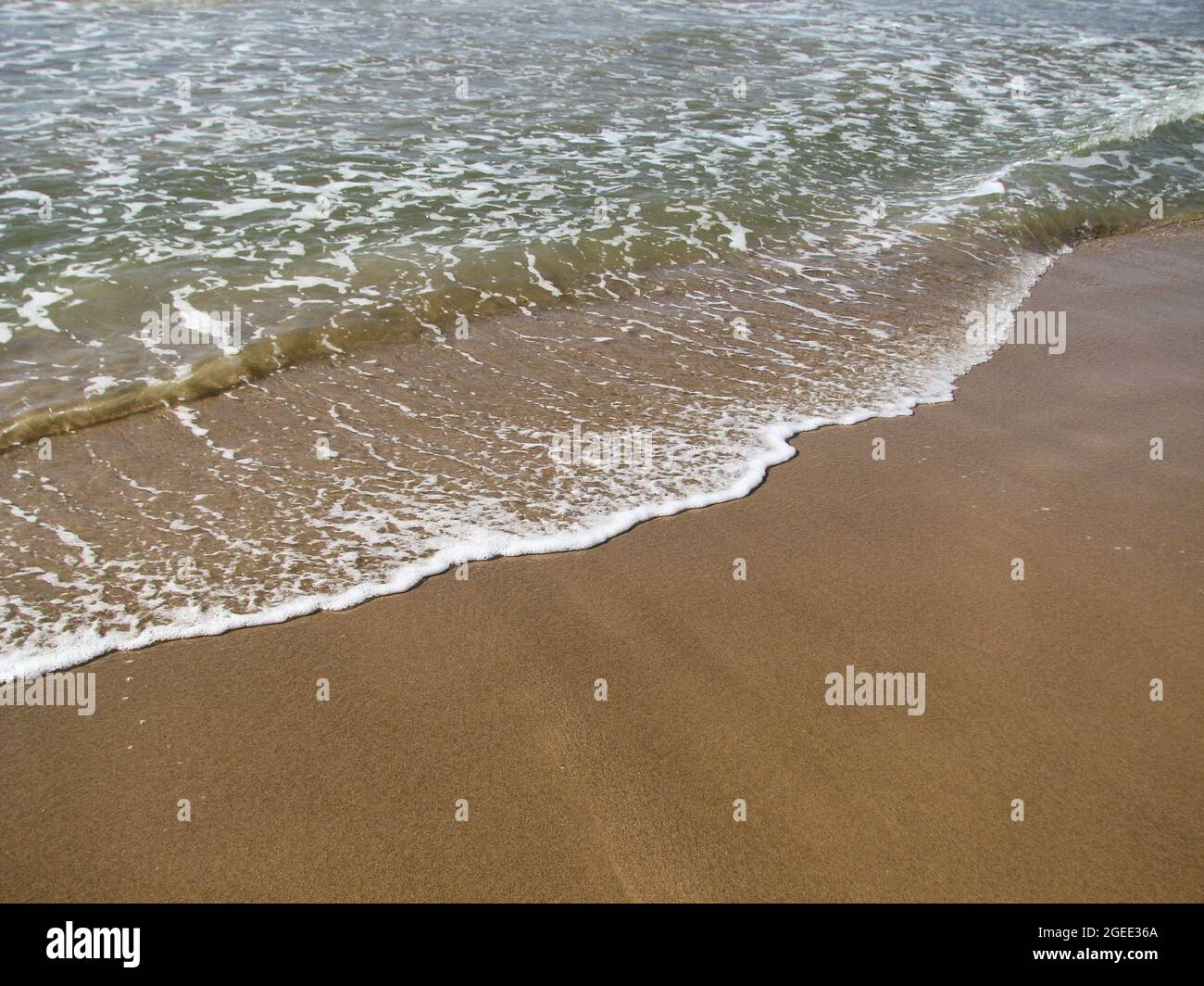 View of the foamy waves of the ocean washing the sandy beach Stock ...