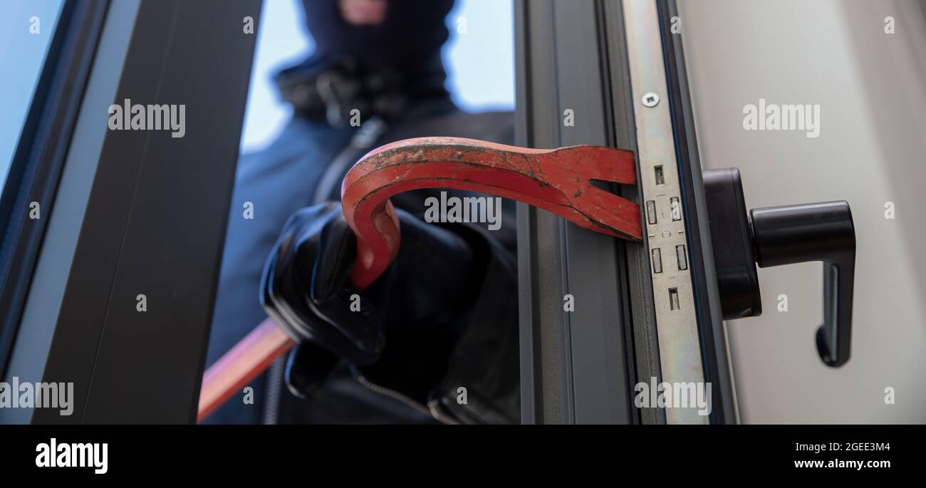 Masked housebreaker entering a house for stealing in the daytime. Thief ...