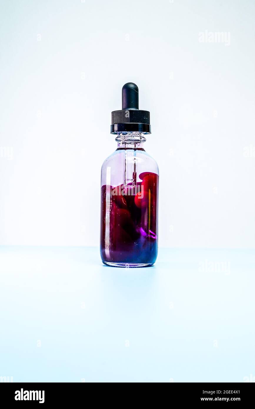 glass flask with purple paint on white background Stock Photo - Alamy