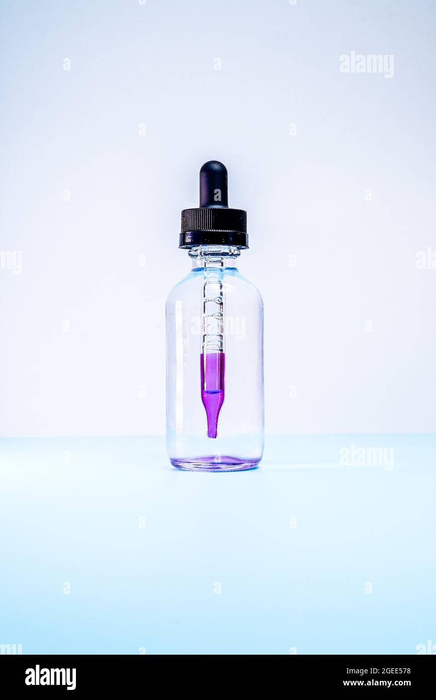 glass flask with purple paint on white background Stock Photo - Alamy