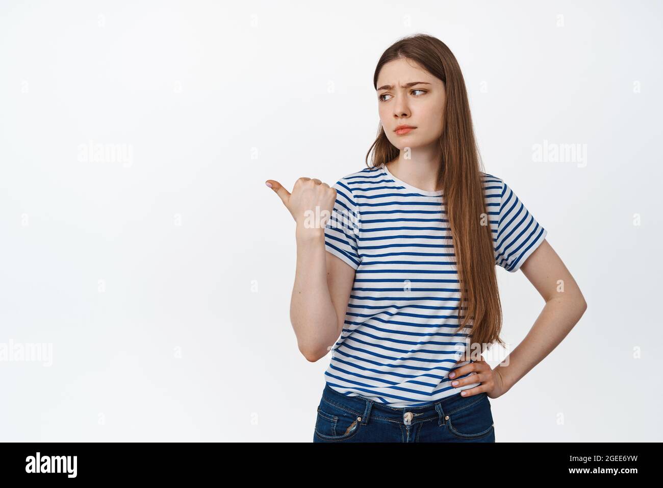 Image of skeptical young woman frowning, pointing and looking lef with ... Image of skeptical young woman frowning, pointing and looking lef with ...