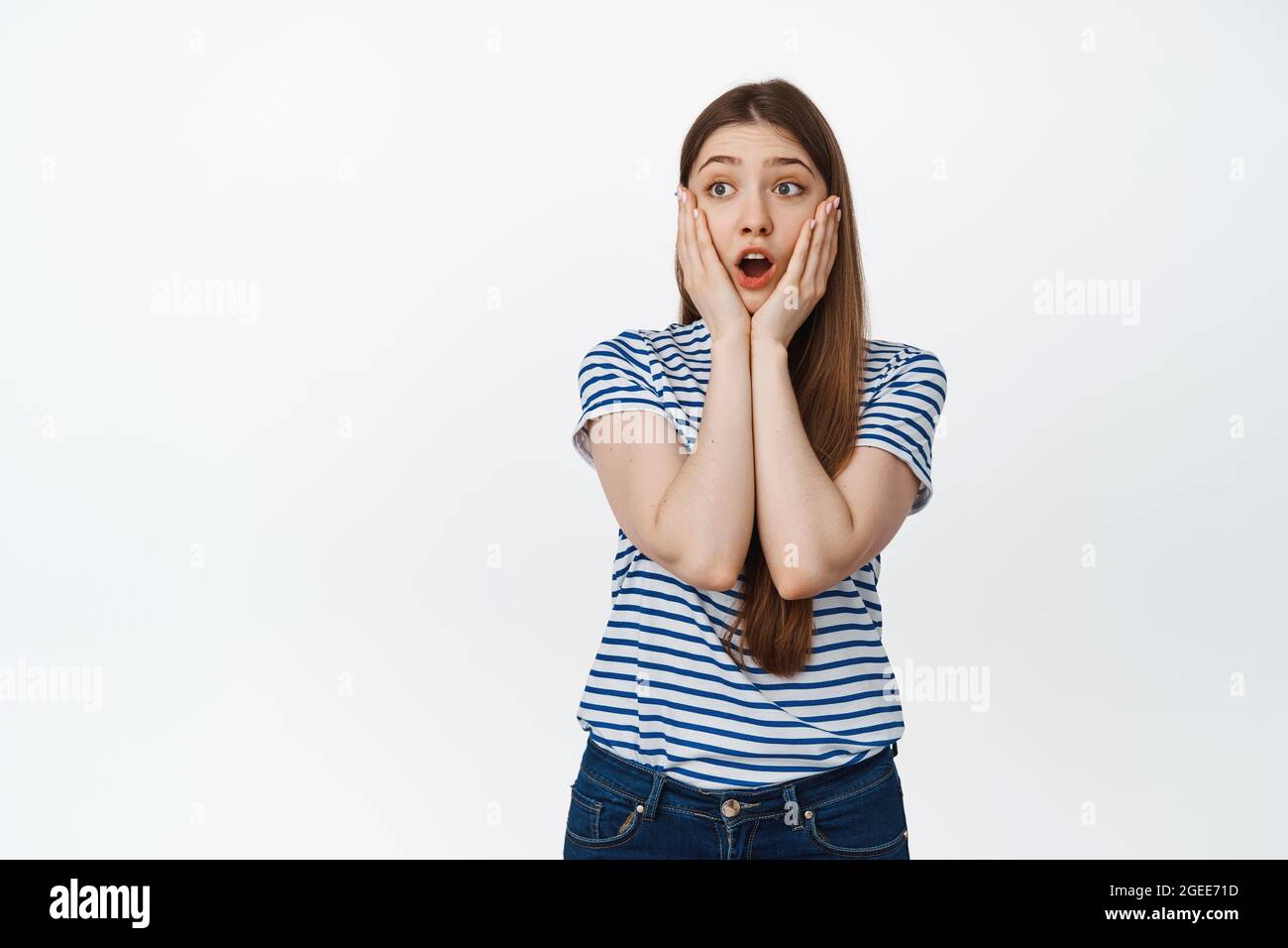 Impressed young woman drop jaw, gasping and looking left with shocked ...