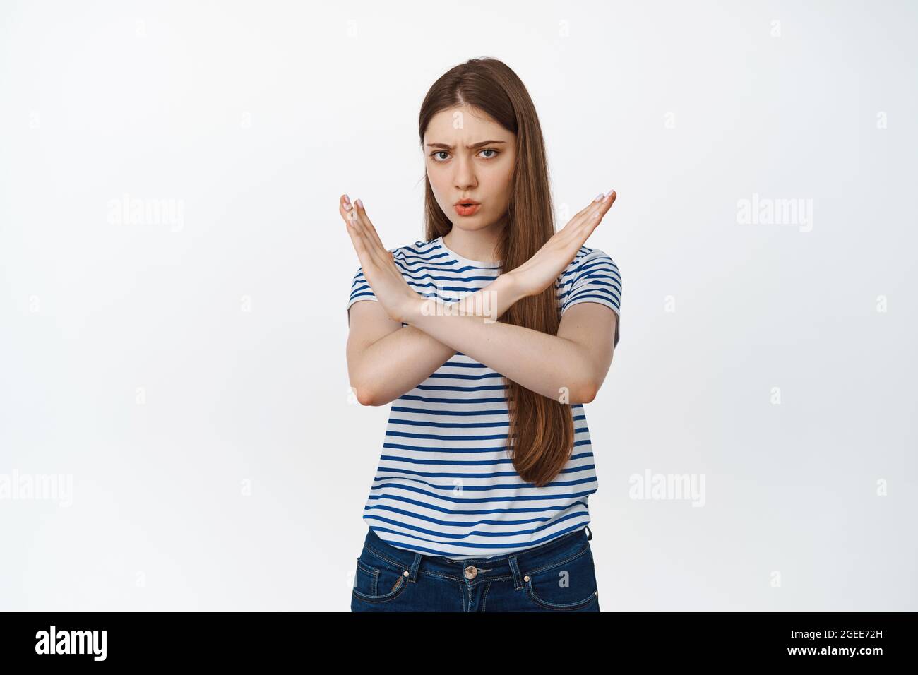 Serious frowning girl showing cross sign, stop prohibit gesture, forbid ...