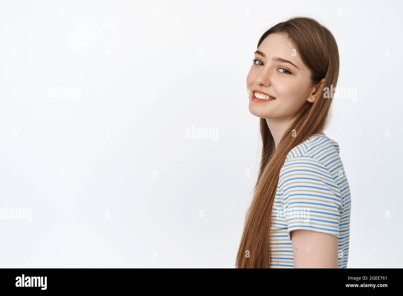 Young happy student turn face at camera and smiles, stands in tshirt ...