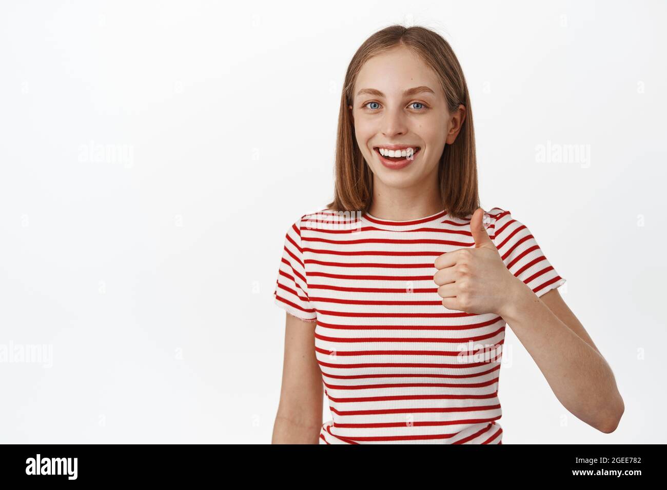 Very good. Smiling young woman, student showing thumb up in approval ...