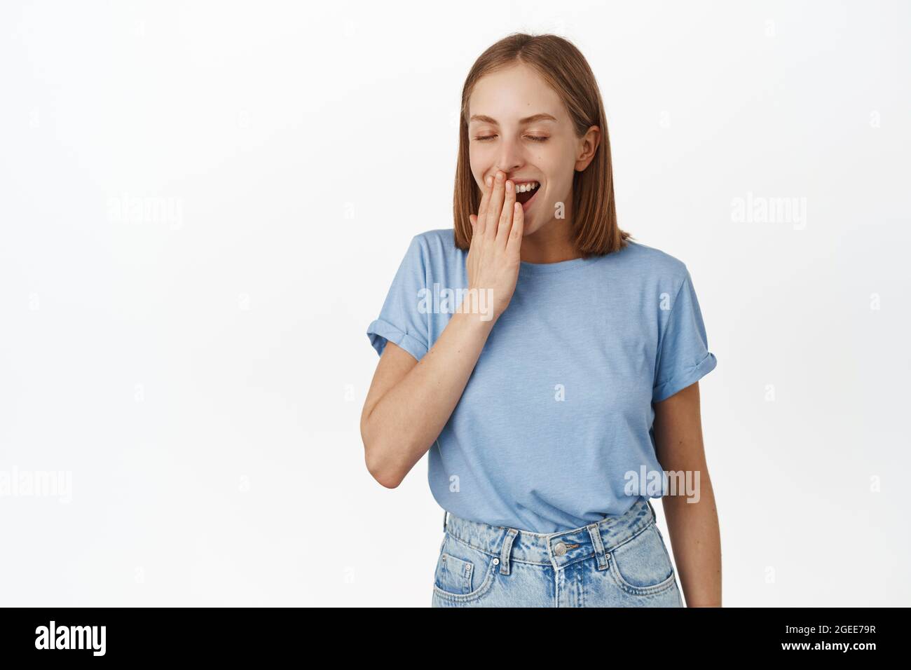 Image of satisfied blond girl, yawning with pleasure, had good night ...