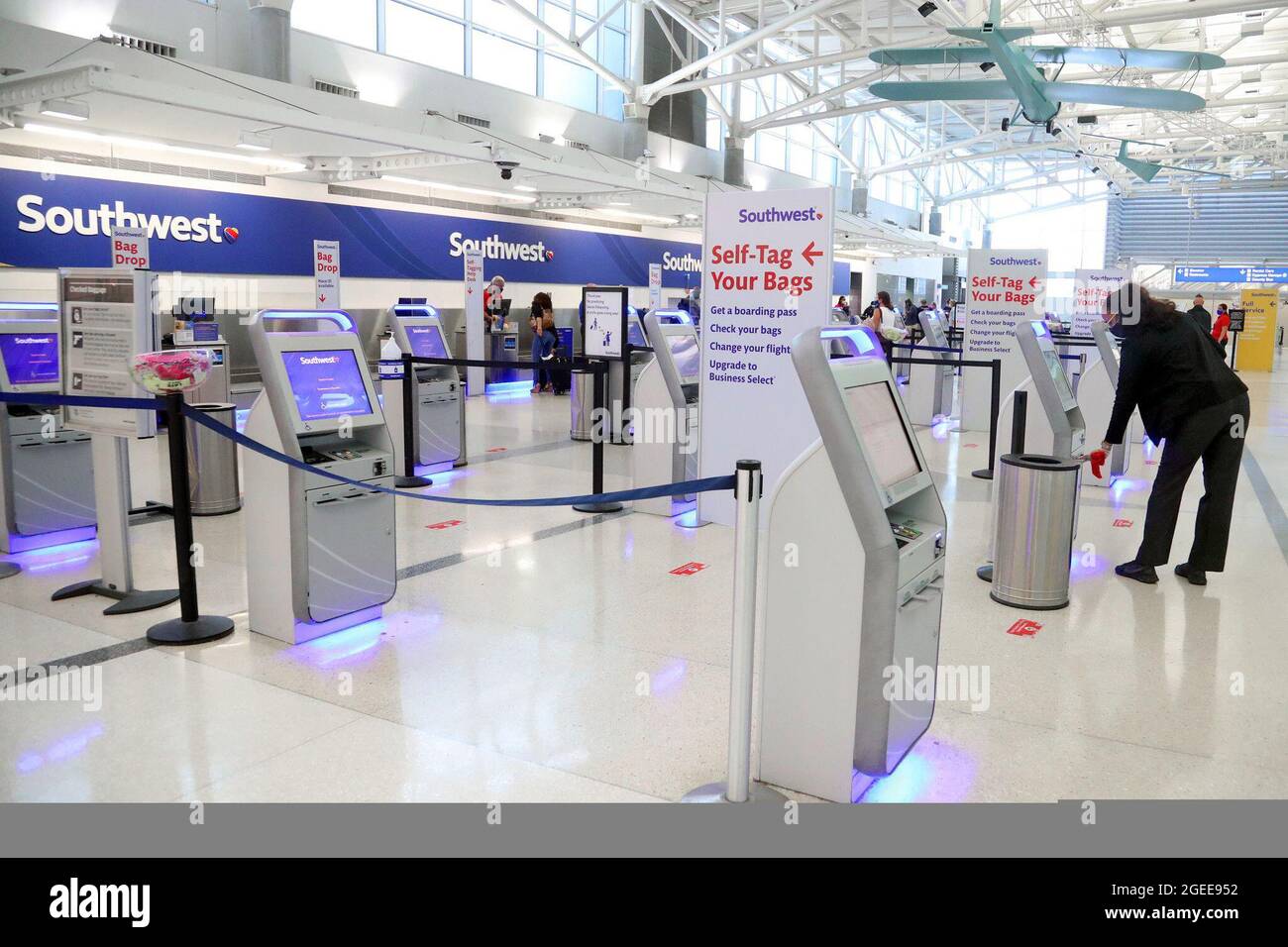An employee cleans check-in kiosks at the Southwest ticket counter at ...