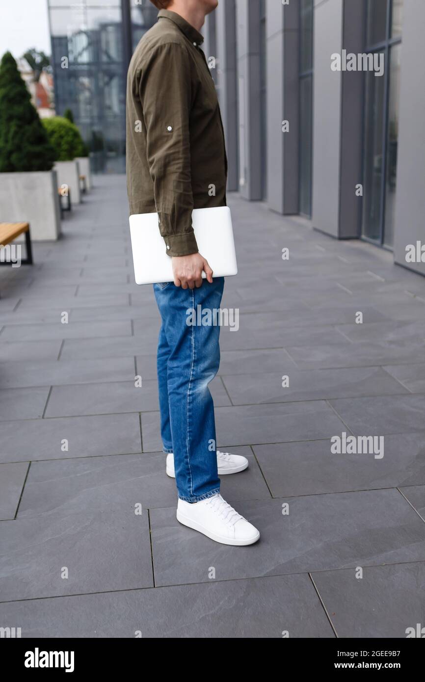 man standing with laptop on the threshold of business center Stock ...