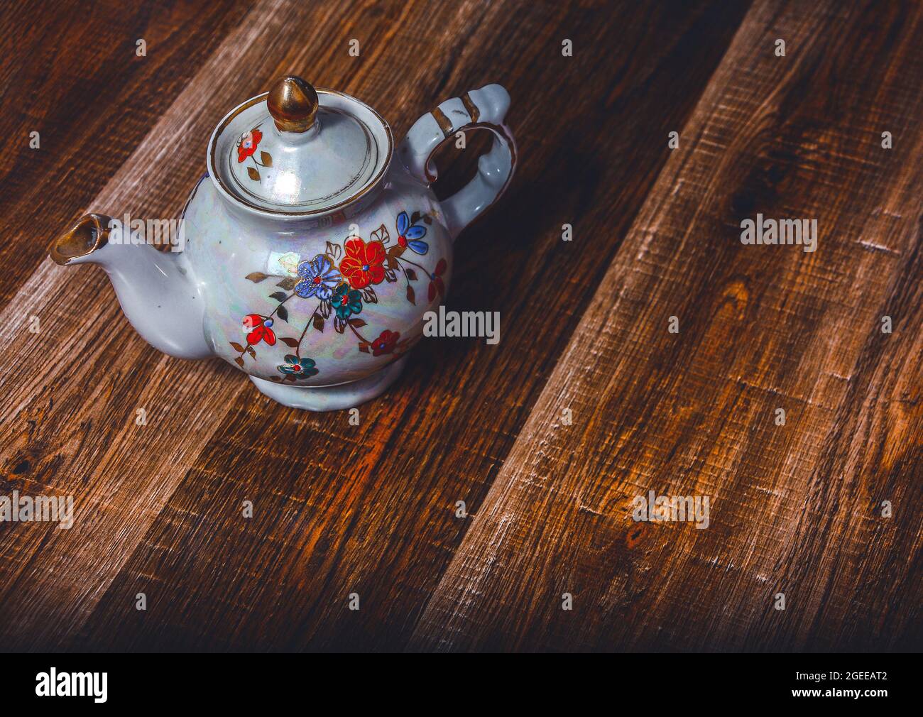 A teapot on the background of an ancient torn texture. Action ...