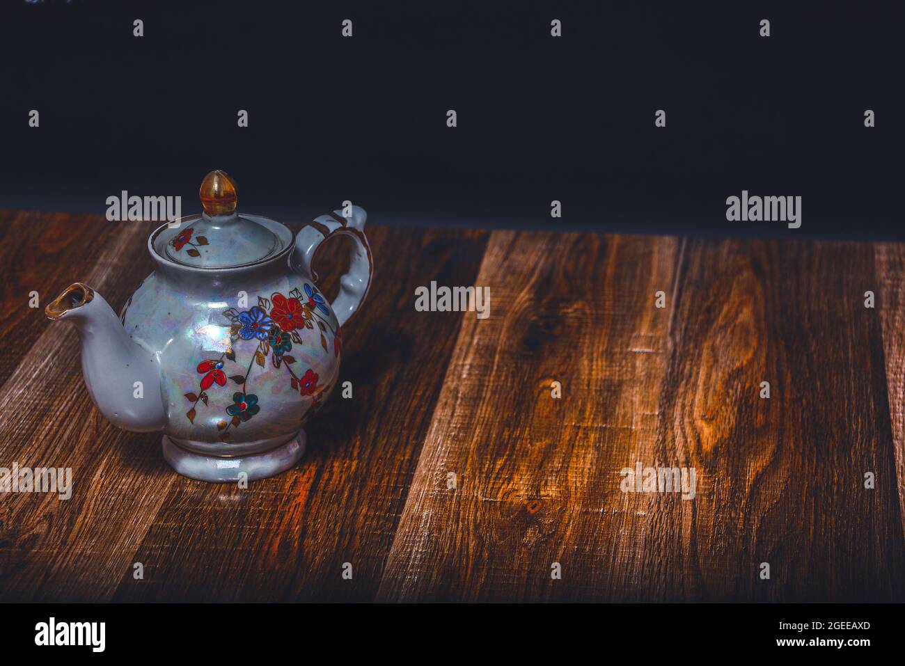 A teapot on the background of an ancient torn texture. Action ...