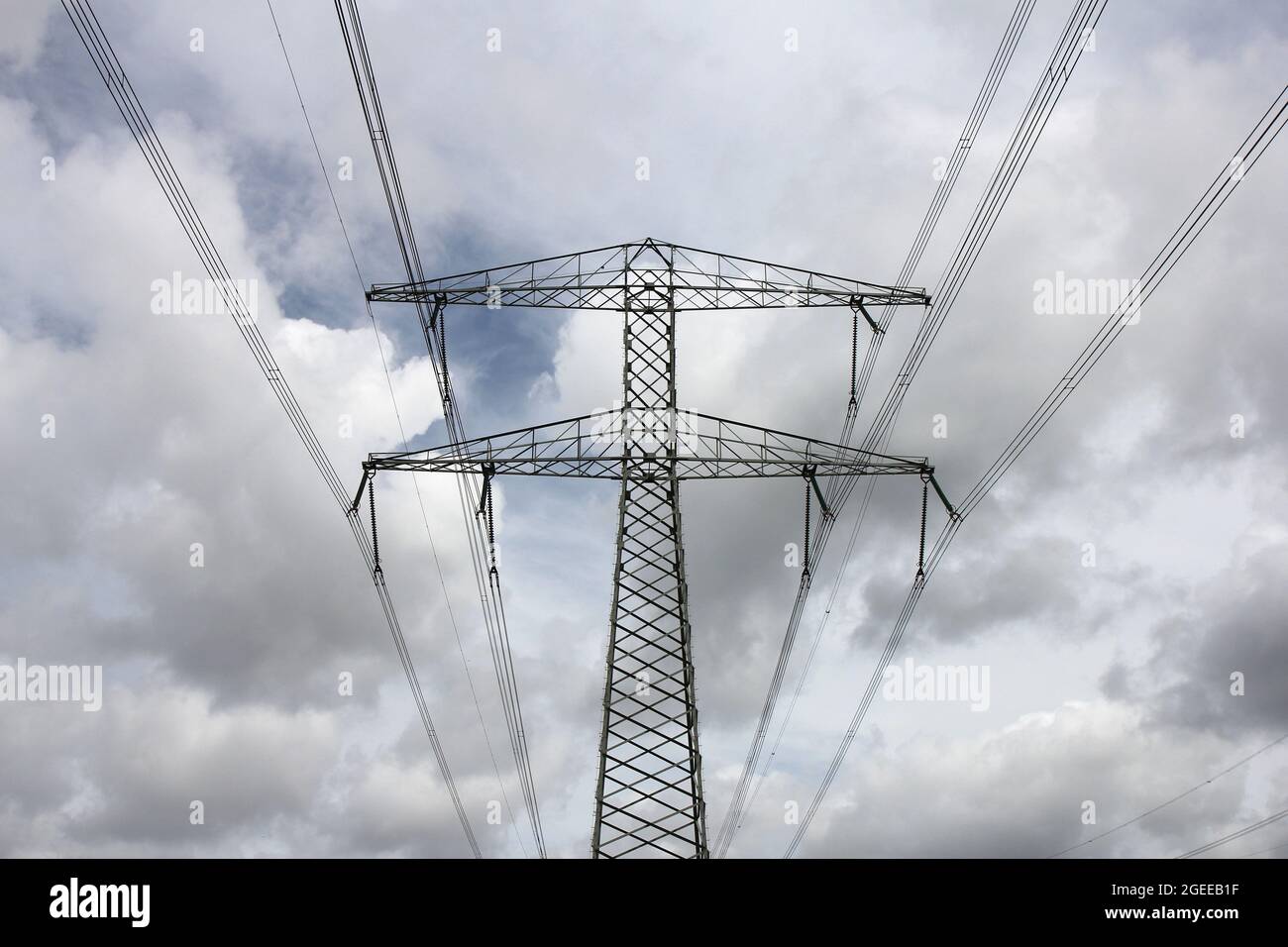 electricity pylon against cloudy sky Stock Photo - Alamy