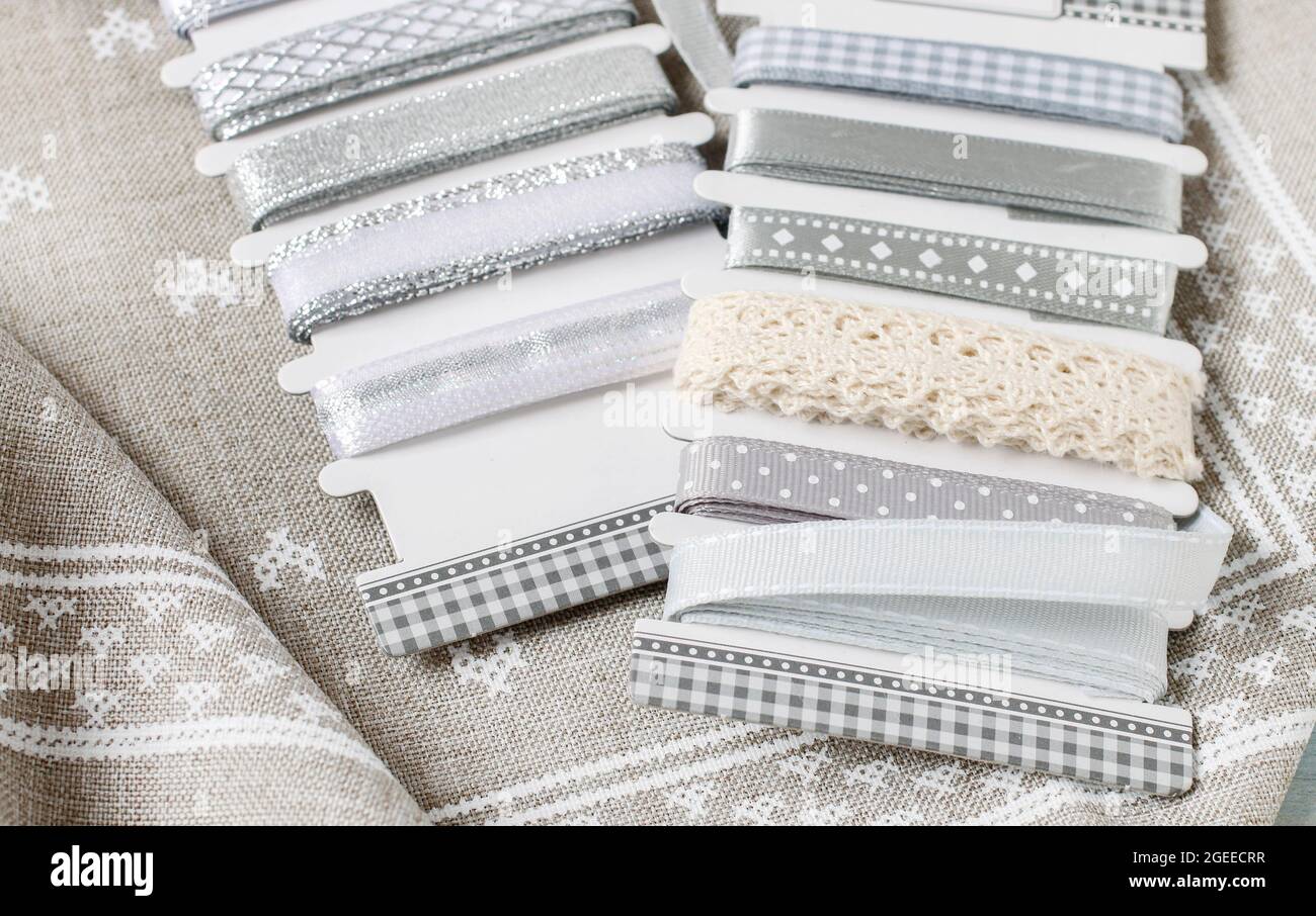 Silver ribbons on grey fabric. Hobby time Stock Photo - Alamy