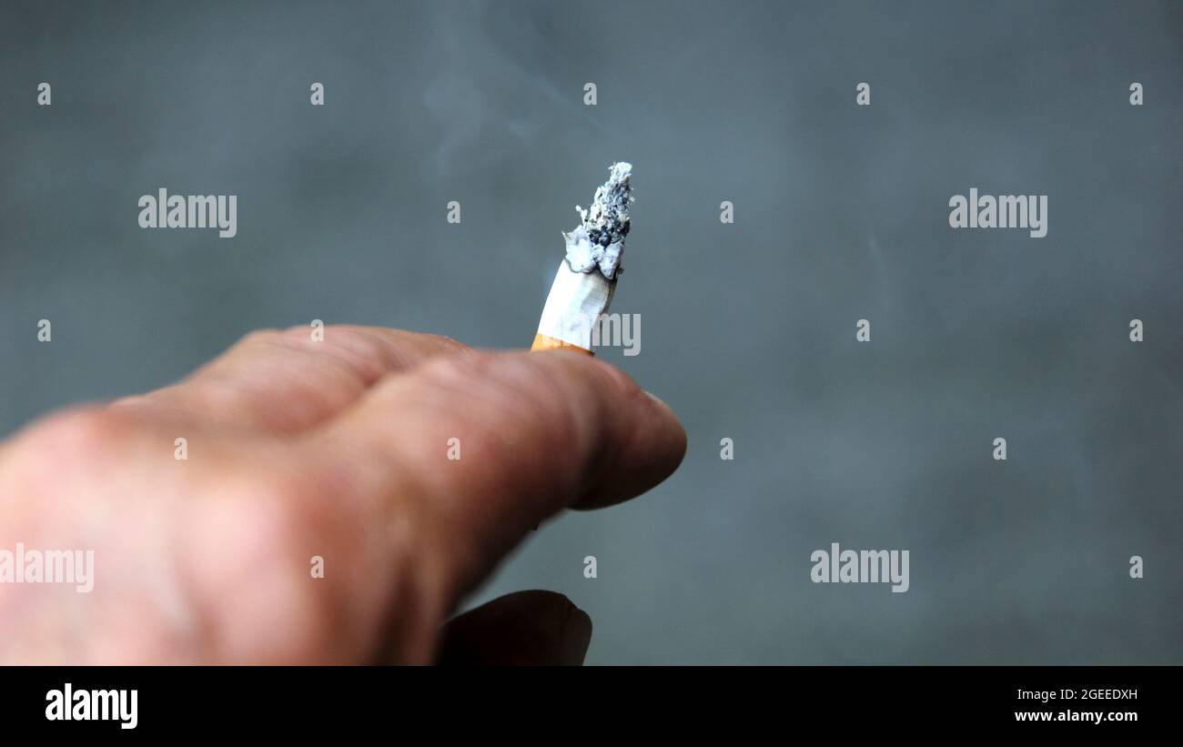 Holding half smoked cigarette hi-res stock photography and images - Alamy