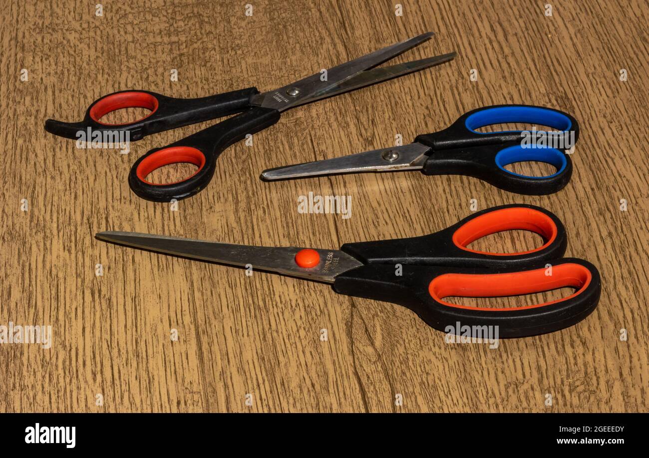 Three scissors on a wood surface Stock Photo - Alamy