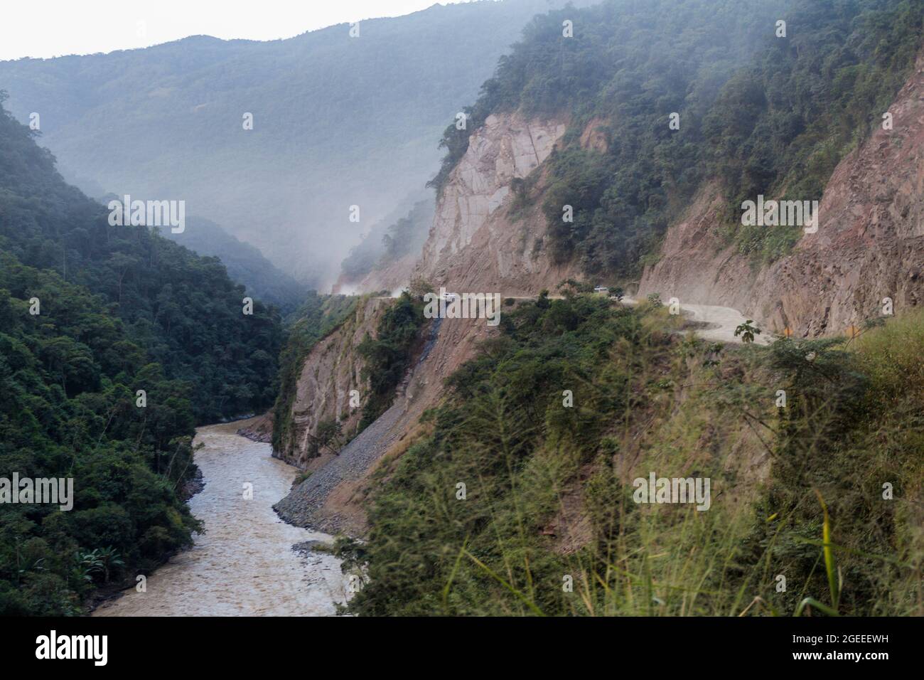 Narrow dangerous road in a valley of Coroico river in Yungas mountains ...