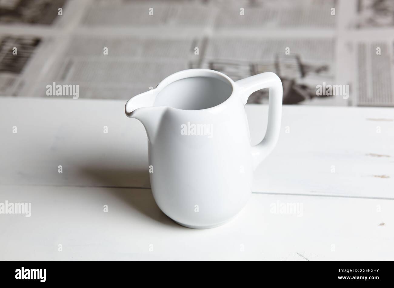 Empty milk jug on wooden background. Porcelain sauce boat, pitcher ...