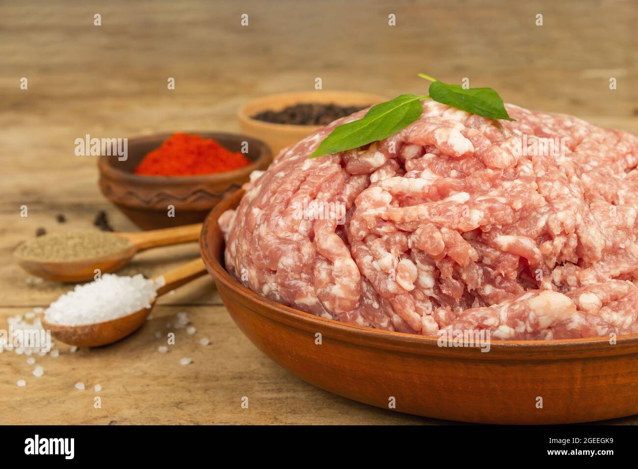 Raw minced meat. Ground pork with spices, cooking oil. Old wooden table ...