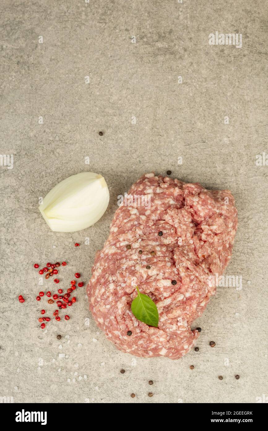 Raw minced pork. Fresh ground meat with spices and onion. Grey stone ...
