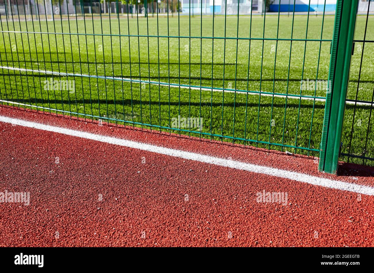 Red treadmill on sport field. Landscape of soccer field with green ...