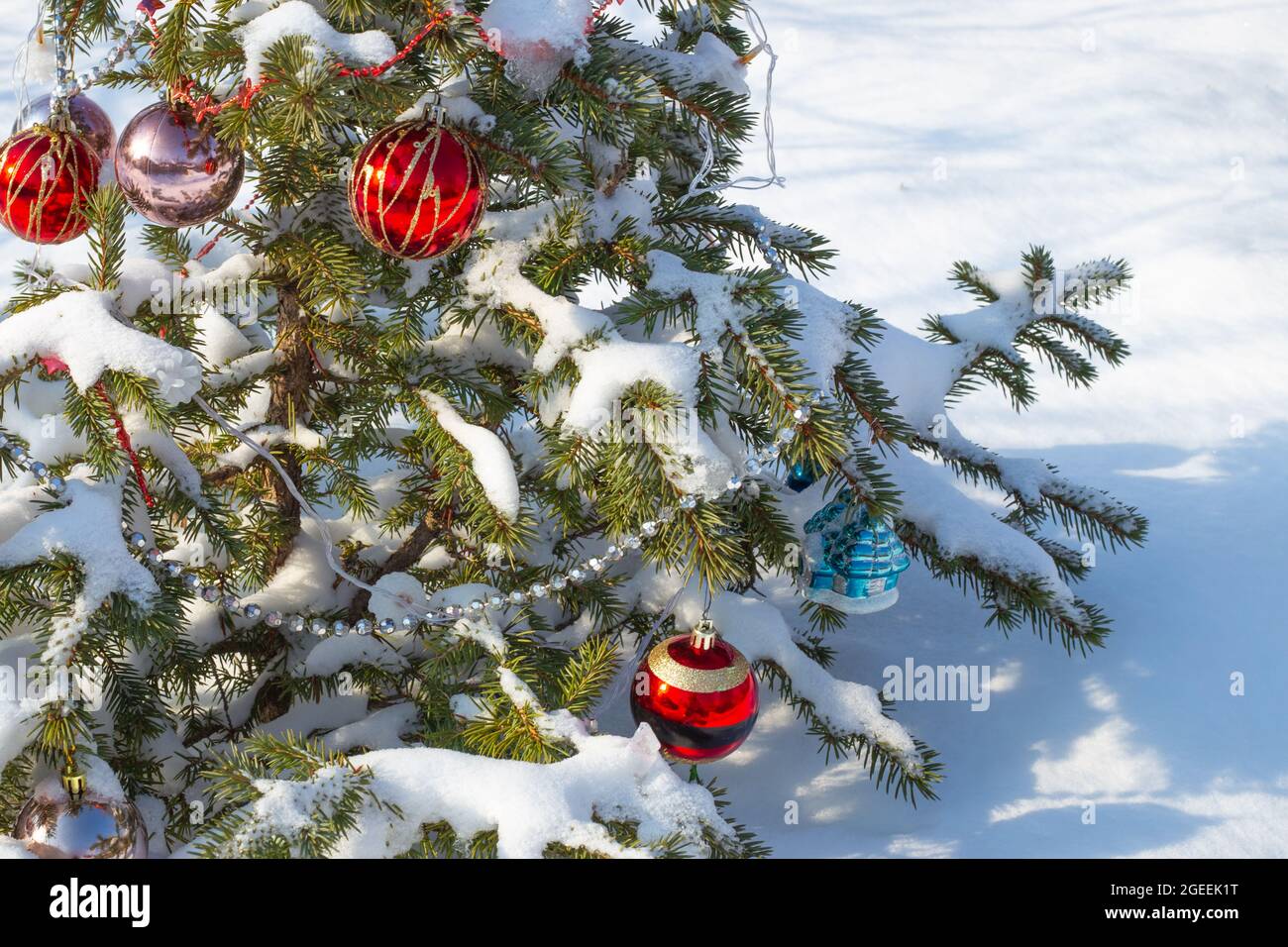Beautiful little Christmas tree decorated with toys and beads outside ...