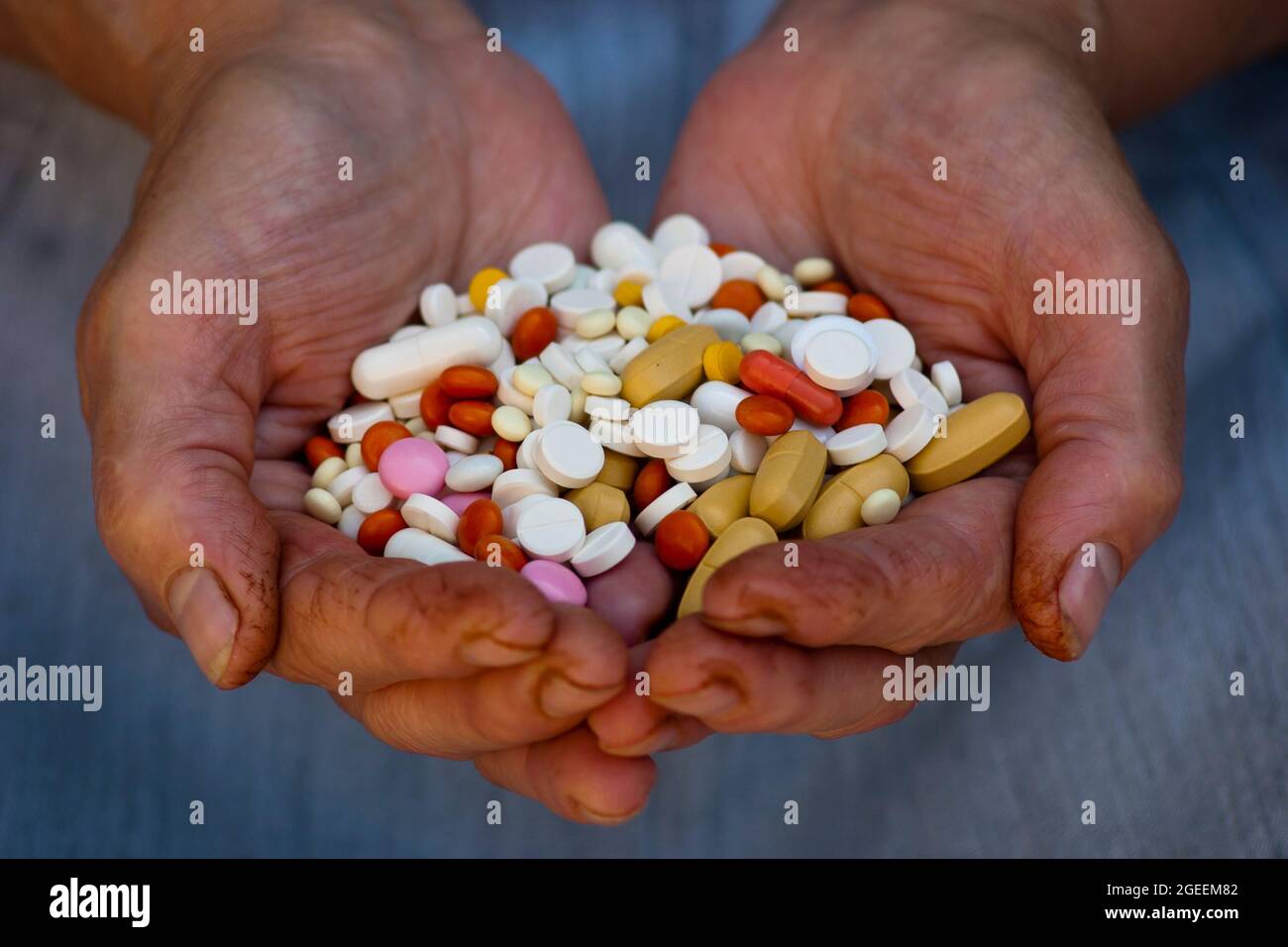 A handful of pills in female hands. A handful of various pills in ...