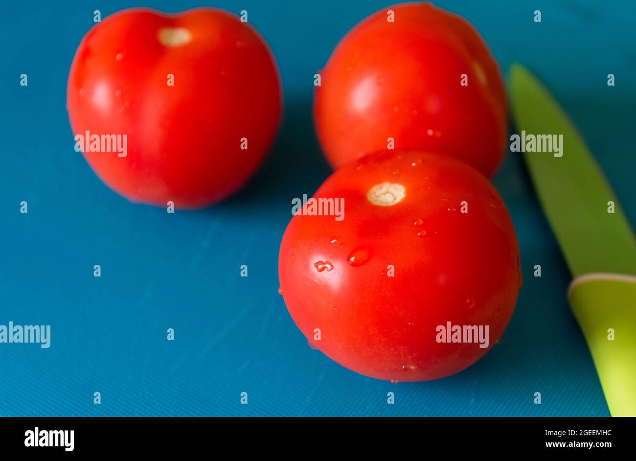 Fresh cherry tomatoes and a knife on a blue background Stock Photo - Alamy
