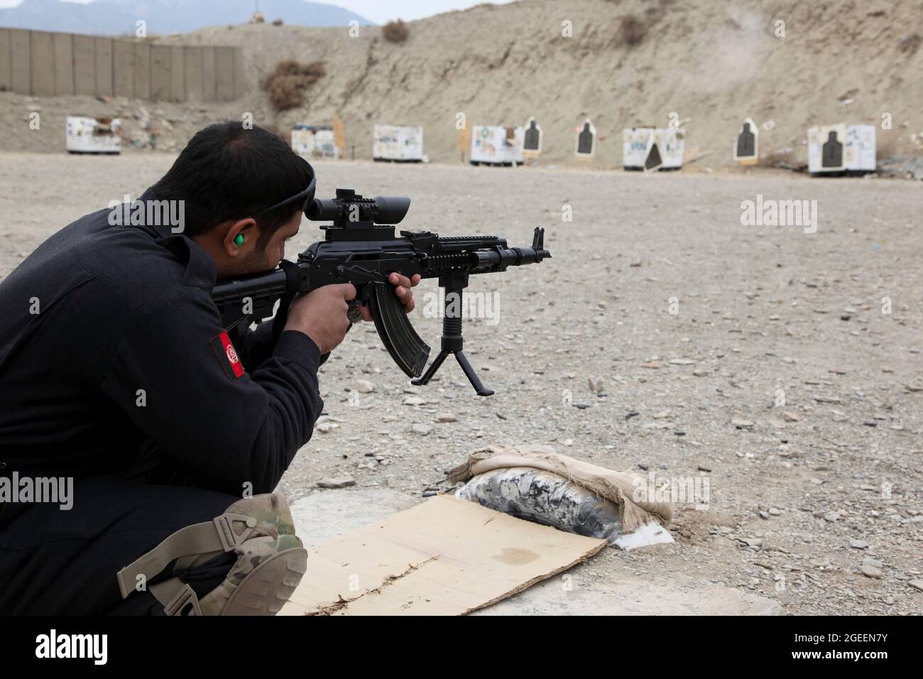 An Afghan Uniformed Policeman, stationed in Khost city, fires his AK-47 ...