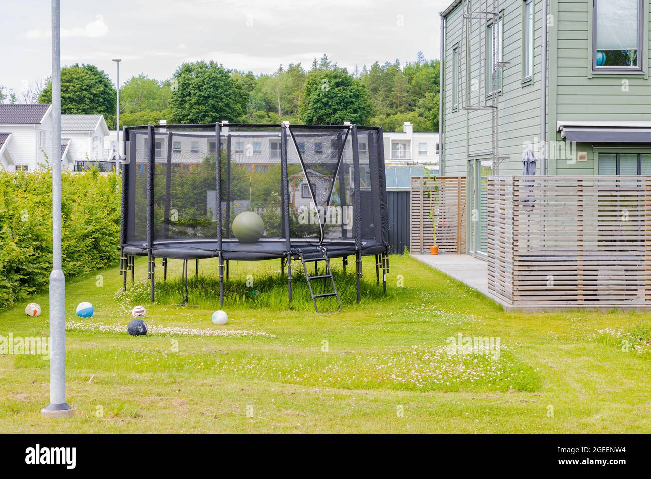 Trampoline with safety net mounted on backyards with football balls ...