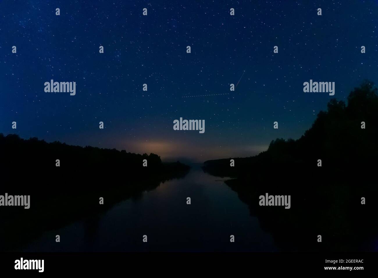 The fading stars in the early morning sky are reflected in a quiet ...