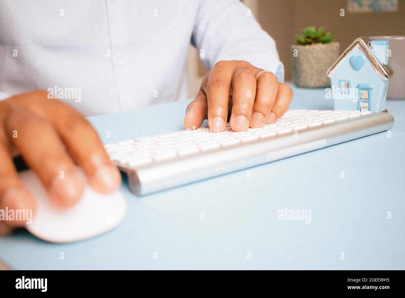 Closeup of a Hispanic man's hands as he holds a computer mouse and ...