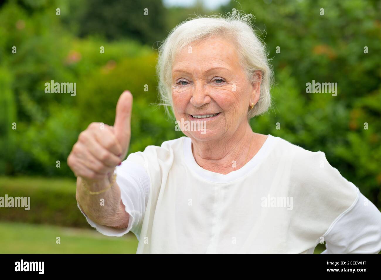 Enthusiastic happy healthy 82 year old woman giving a thumbs up gesture ...