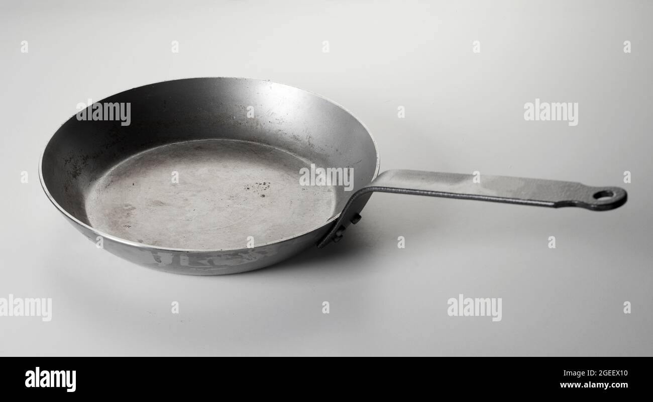 Empty small old aluminum frying pan with a handle on white background ...