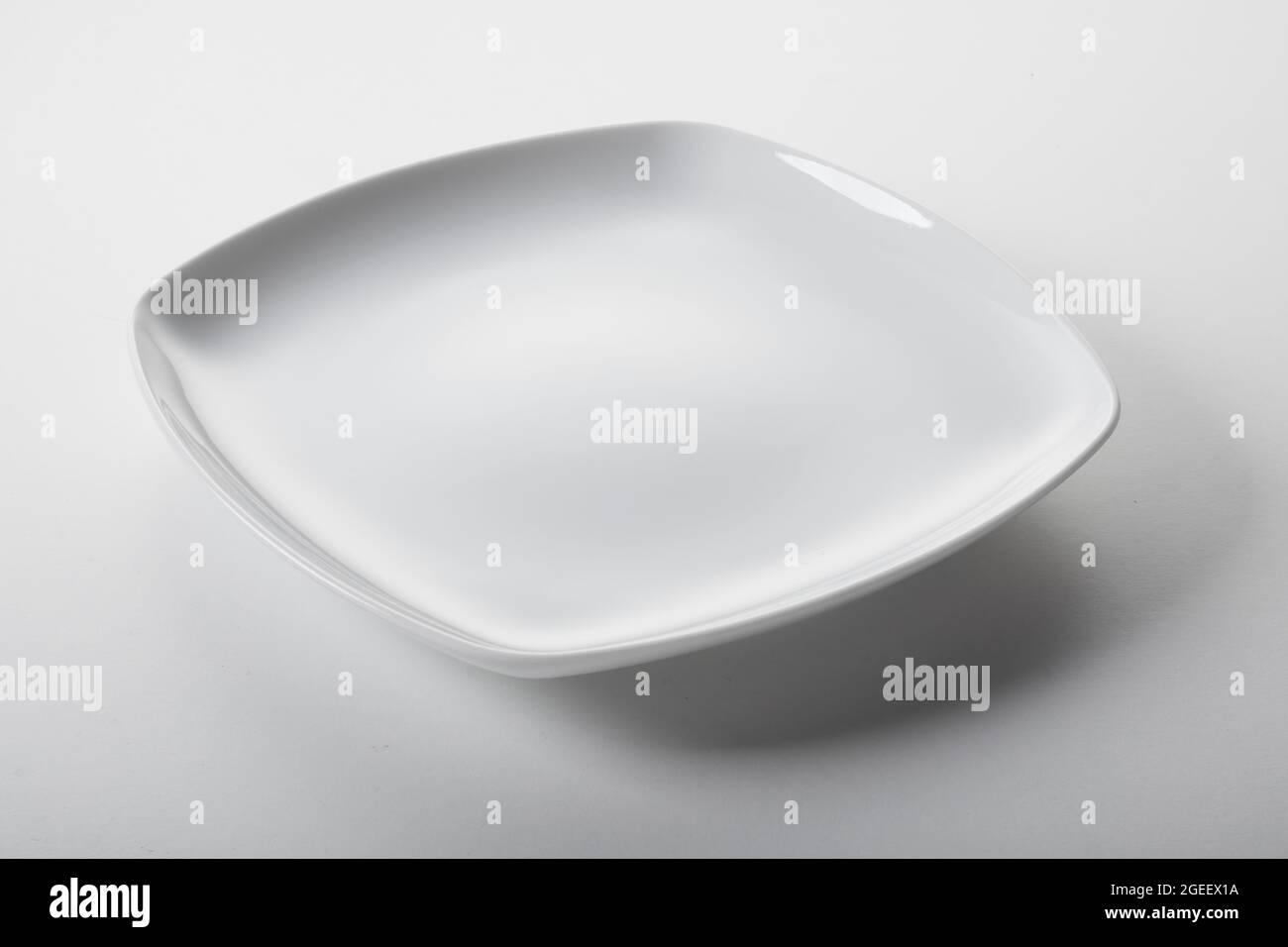 White square curved plate in shiny white enamel in minimalist style on ...