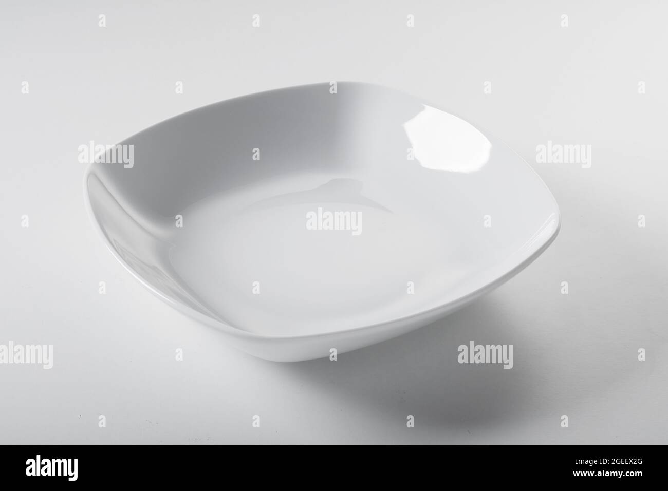 Ceramic empty square-shaped white bowl with shiny enamel on white ...