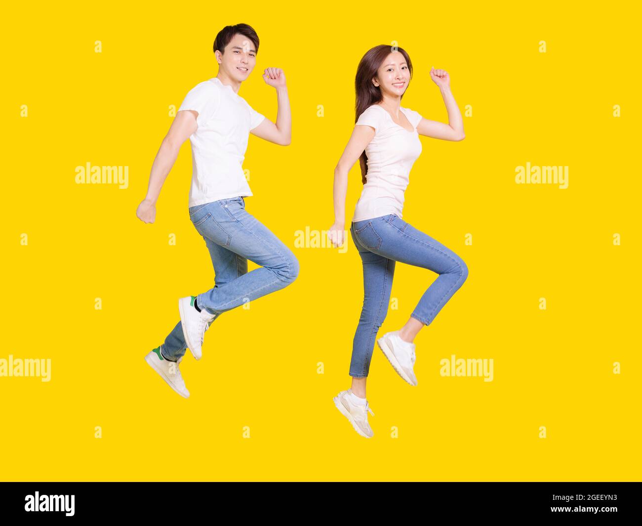 Full length photo of young couple jumping and running isolated yellow ...