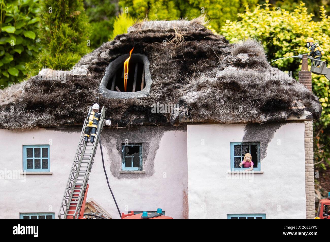 Closeup of tiny model cottage with the roof on fire Stock Photo - Alamy