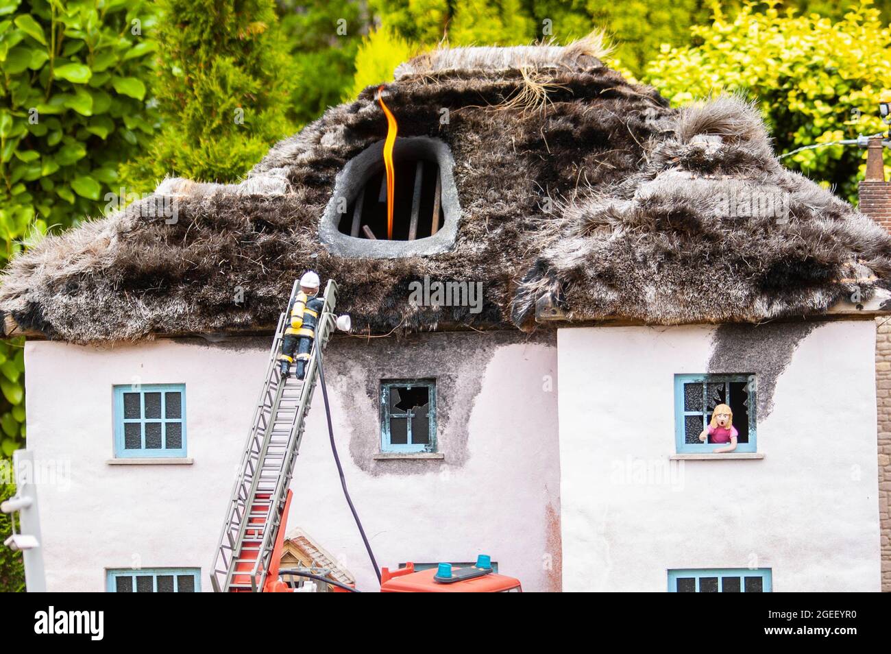 Closeup of tiny model cottage with the roof on fire Stock Photo - Alamy