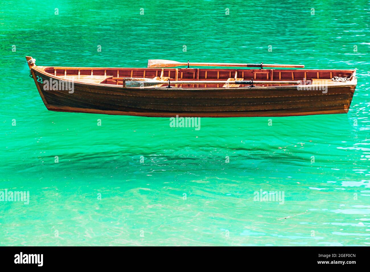 Shot of an empty wooden rowboat on crystal clear water Stock Photo - Alamy