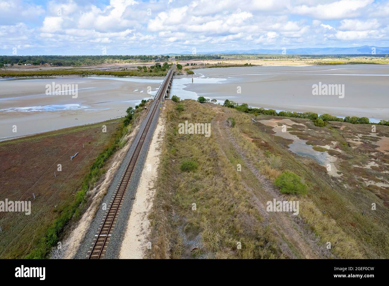 Drone flight along a rail line and towards a bridge crossing over a ...